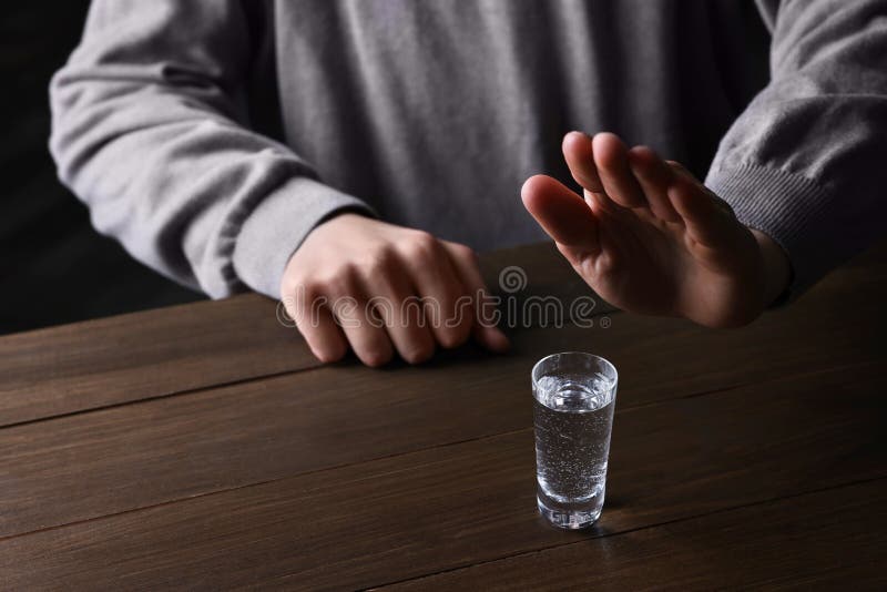 Man Refusing To Drink Vodka at Wooden Table, Closeup. Alcohol Addiction ...