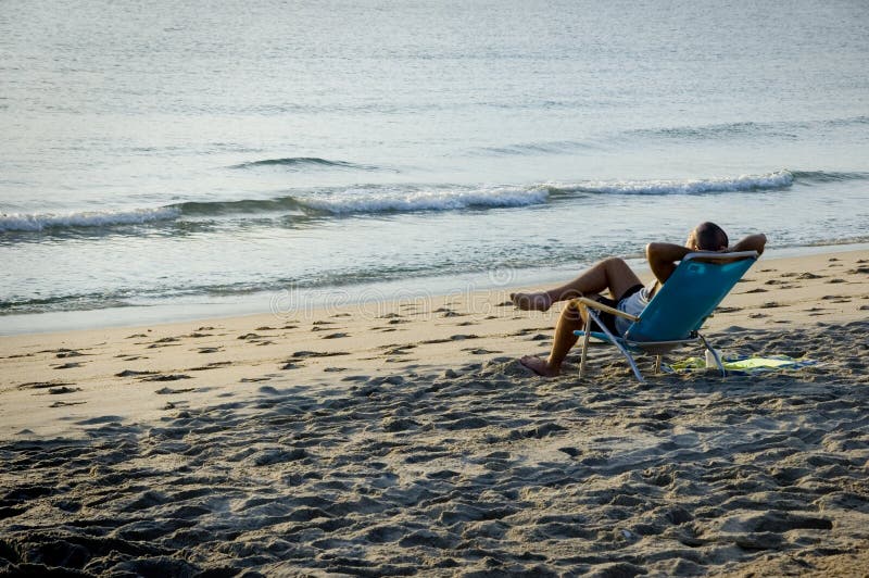 Man relaxing on beach stock photo. Image of living, resort - 1366956