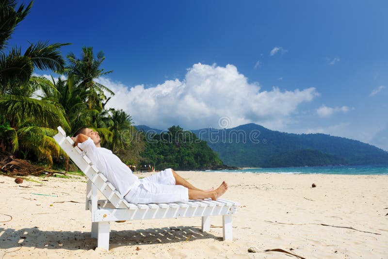 Man relaxing on a beach stock photo. Image of leisure - 29319248