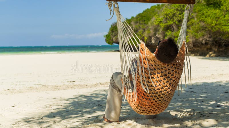 Man Relaxing in a Hammock on the Beach on Holidays. Stock Image - Image ...