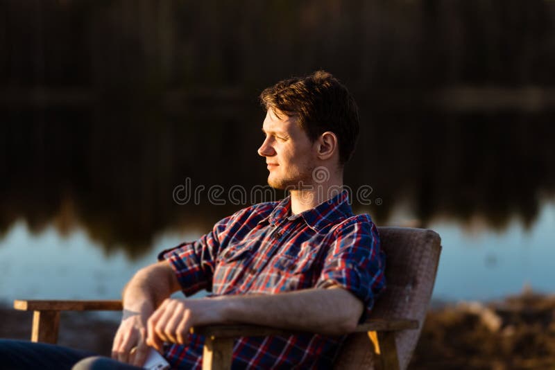 Man relaxing by a lake stock photo. Image of dock, lake - 87693674