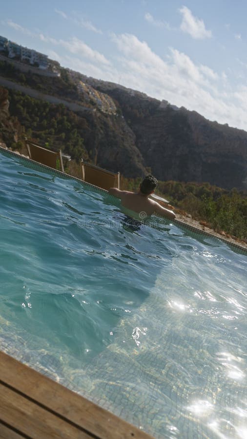 Man Relaxing in an Outdoor Infinity Pool Overlooking a Stunning ...