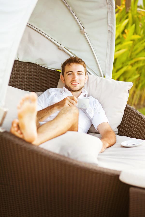 Man relaxing at resort stock image. Image of deckchair - 61746499