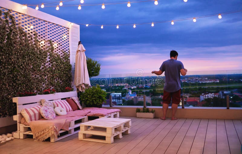 A Man Relaxing on Rooftop Patio at Summer Evening Stock Photo - Image ...