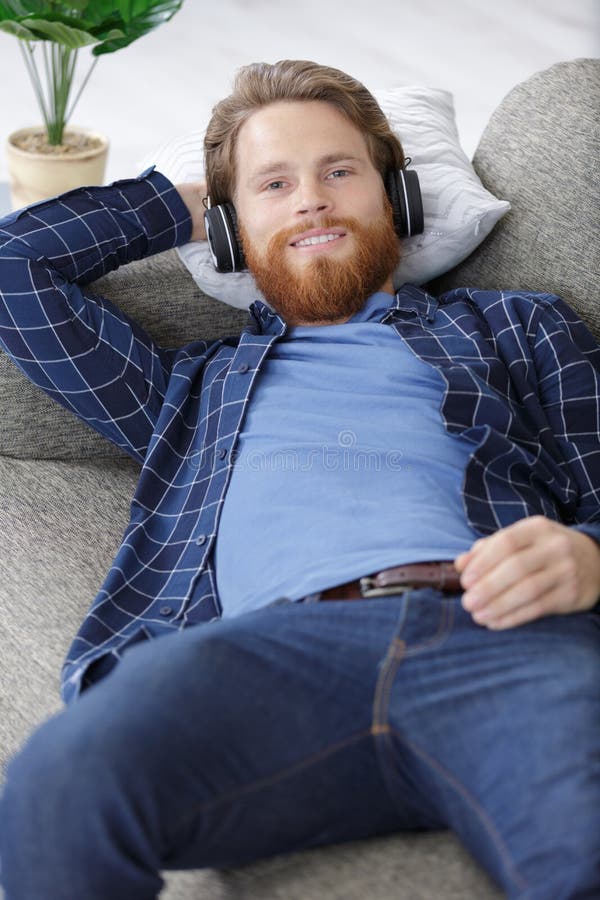 Man Relaxing on Sofa with Headphones in Living Room Stock Image - Image ...