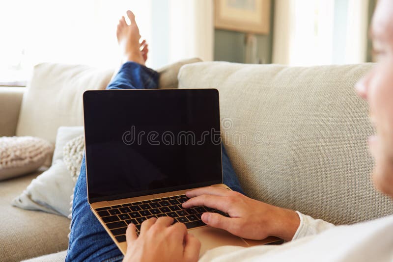 Man Relaxing on Sofa at Home Using Laptop Computer Stock Photo - Image ...