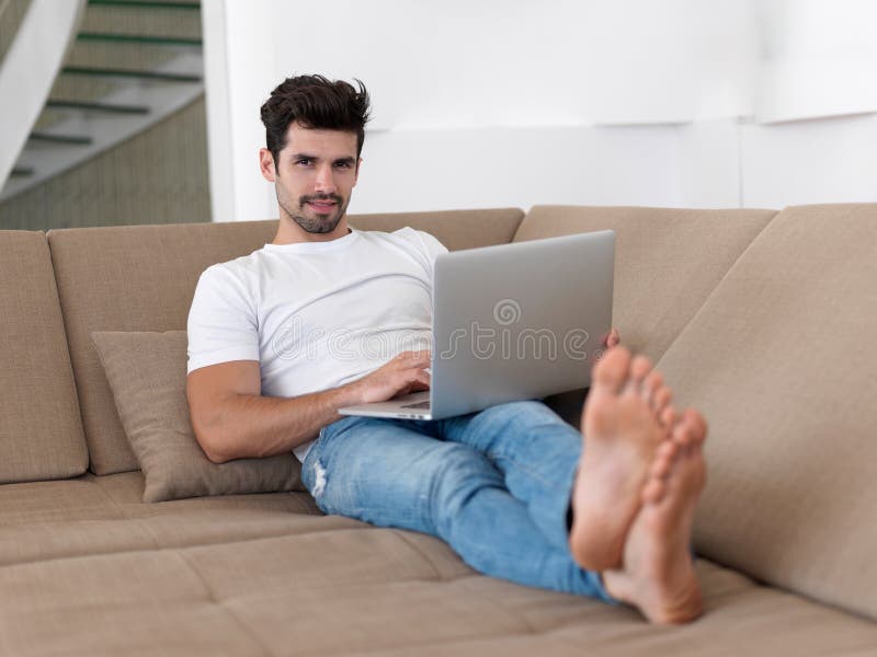 Man Relaxing on Sofa with Laptop Stock Photo - Image of real, relaxed ...