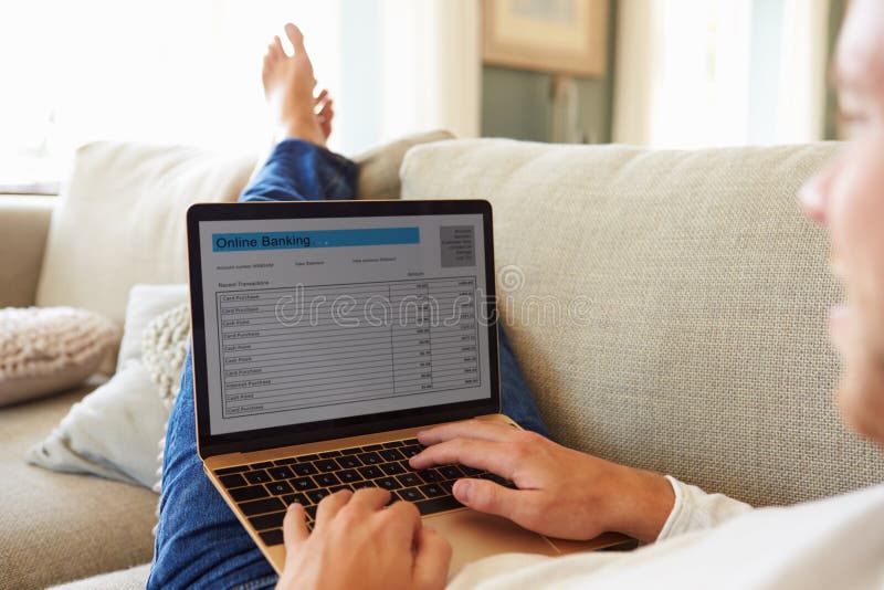 Man Relaxing on Sofa Using Internet Banking on Laptop Computer Stock ...
