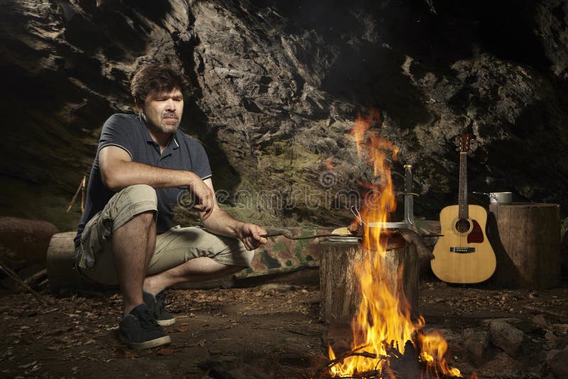 Man Relaxing in Wilderness and Preparing Hunted Fish on Fire Stock ...