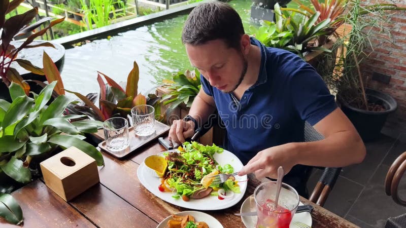 A Man is Relishing a Delightful Meal and Drinks in a Modern Cafe Stock ...