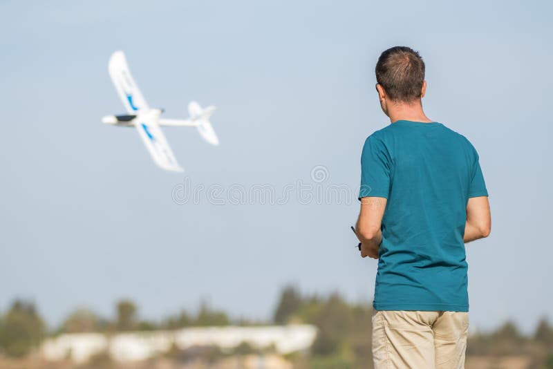 A man flying a model plane stock image. Image of trees - 24042989