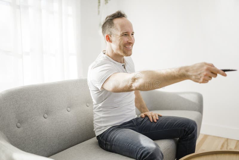 Man with Remote Control on the Sofa at Home Stock Image - Image of ...