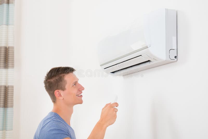Man with Remote Control To Operate Air Conditioner Stock Image - Image ...