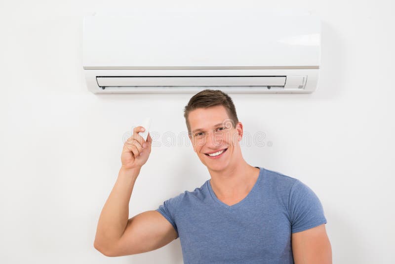 Man with Remote Control To Operate Air Conditioner Stock Photo - Image ...
