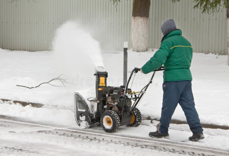 Man Removes Snow by Using a Snow Throwing Machine. Stock Image - Image ...