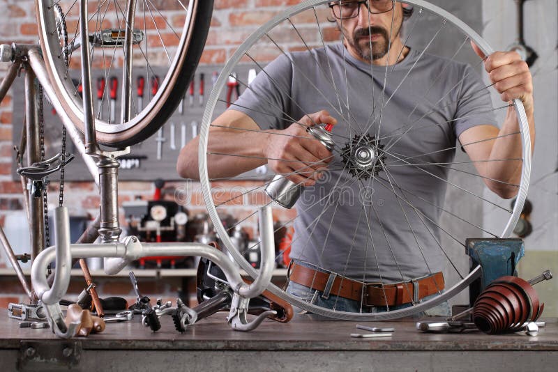 Man Repair the Vintage Bicycle in Garage Workshop on the Workbench with ...