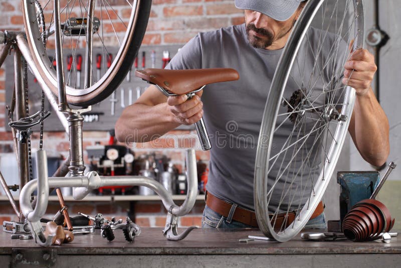 Man Repair the Vintage Bicycle in Garage Workshop on the Workbench with ...