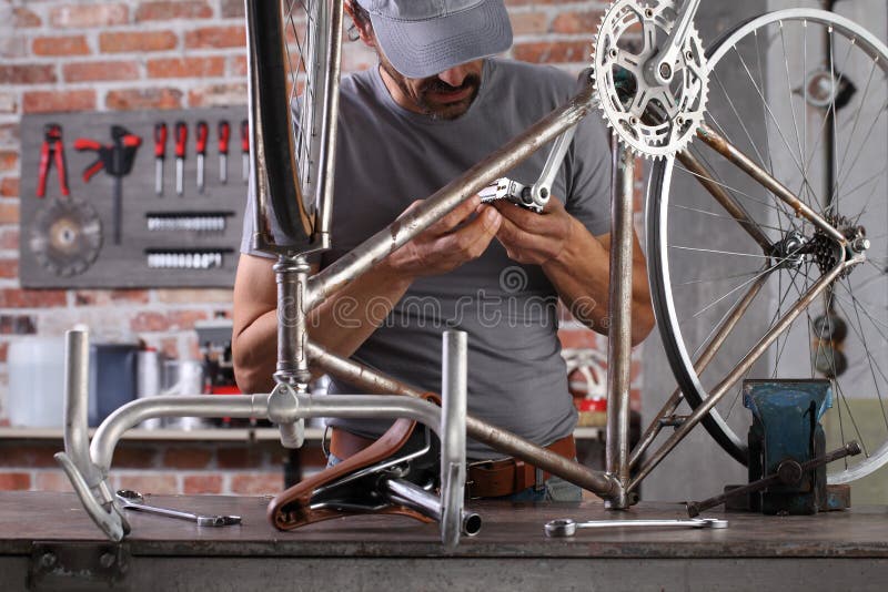 Man Repair the Vintage Bicycle in Garage Workshop on the Workbench with ...