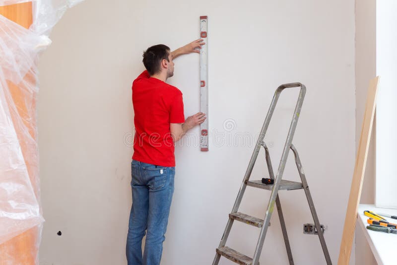 Man Repair Worker Checking Level of the Wall with the Bubble Level Tool ...