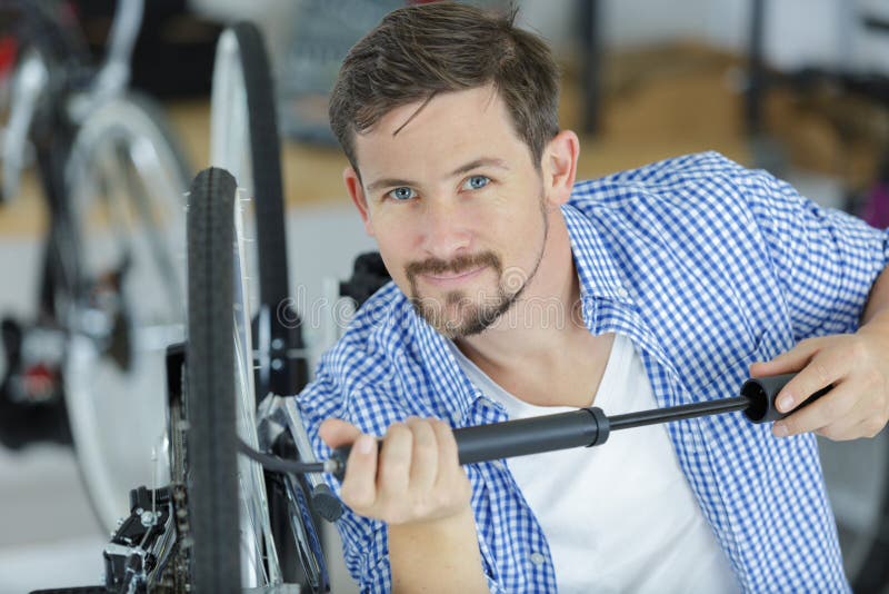 Man Repairing Bike Pumping Wheel Stock Image - Image of gear, bike ...