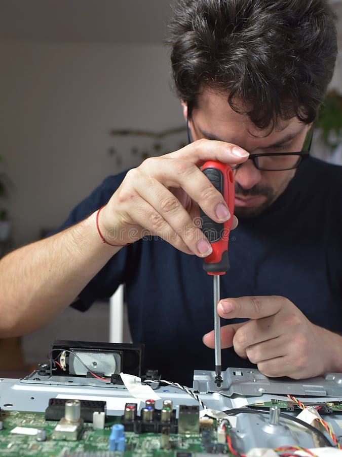 The Man Repairing Broken. he Installs a TV Screen. Stock Image - Image ...