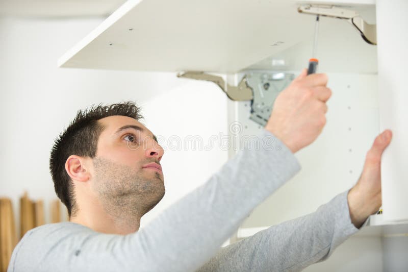 Man repairing cabinet stock photo. Image of installing - 271108378