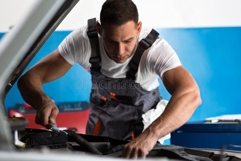 Man repairing car stock image. Image of expertise, coveralls - 73439537