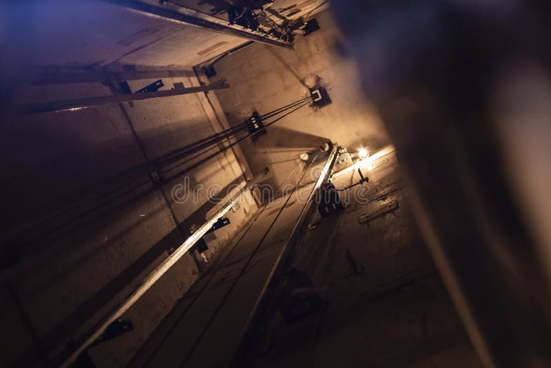 Man Repairing an Elevator at Night Inside a Shaft of a High-rise ...