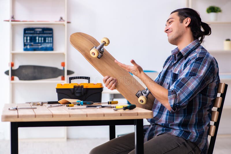 Young Man Repairing Skateboard at Workshop Stock Photo - Image of rider ...
