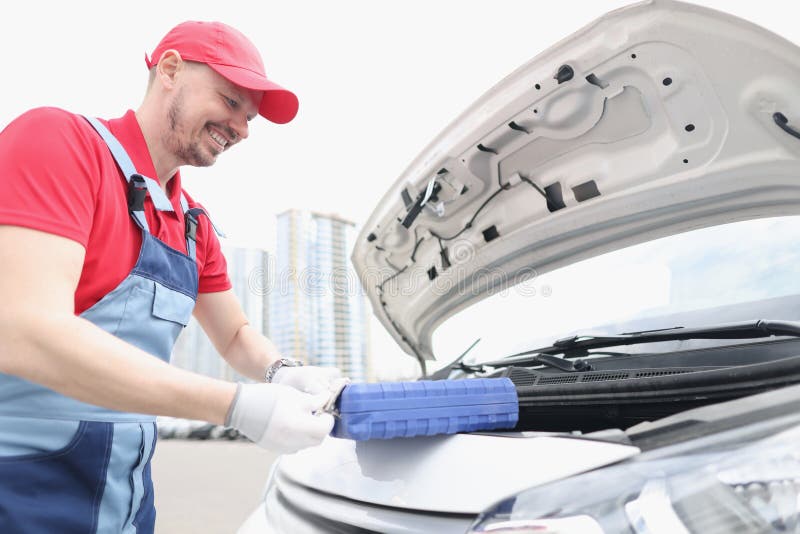 Man Repairman in Uniform Opening Suitcase with Tools on Hood of Car ...