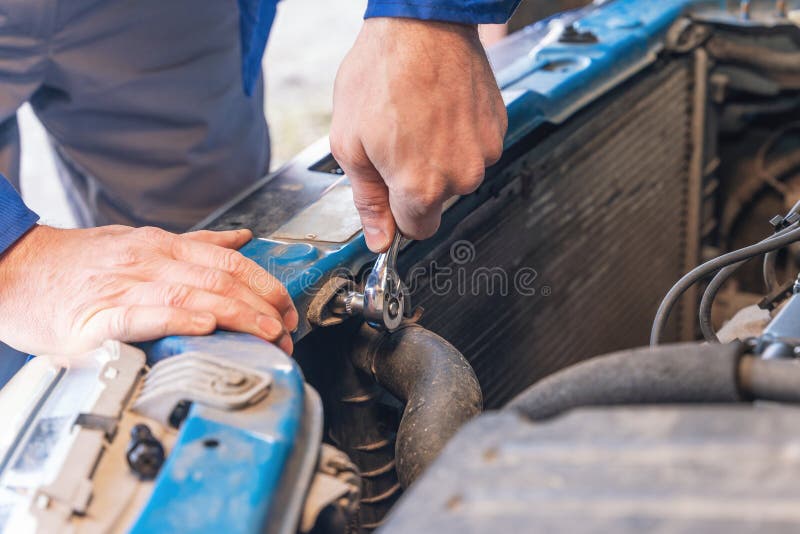 A Man Replaces an Old Broken Radiator in a Car with a New One Stock ...