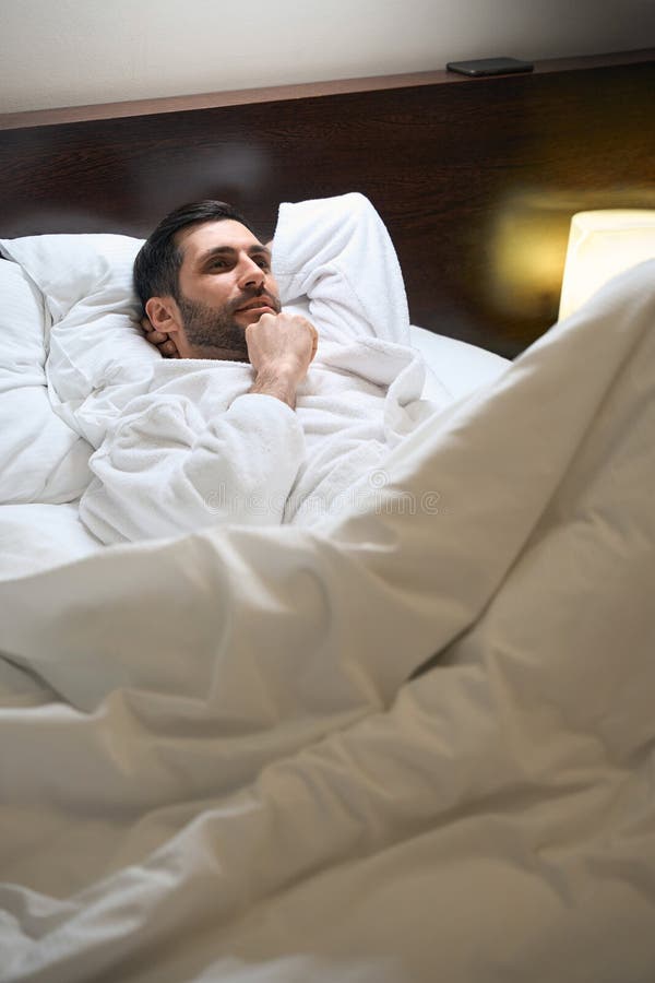 Man is Resting in Bed on Soft Pillows in Hotel Room Stock Photo - Image ...