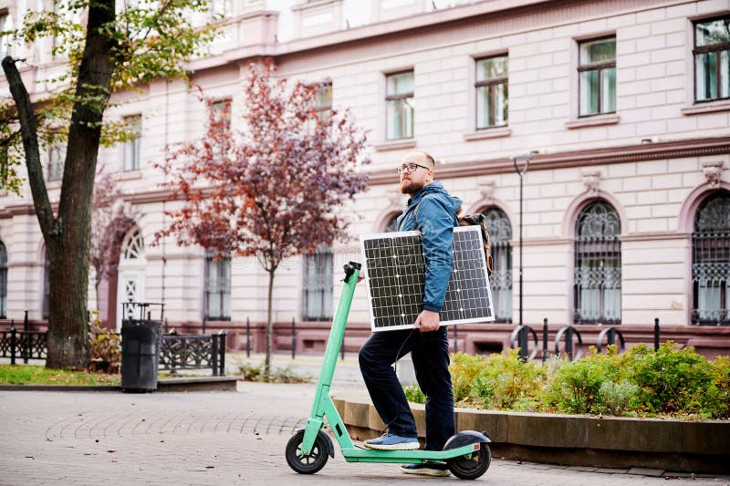 Man Rides Electric Scooter with Solar Panel. Integration of Solar Power ...