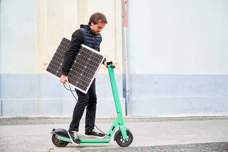 Man Rides Electric Scooter with Solar Panel. Integration of Solar Power ...