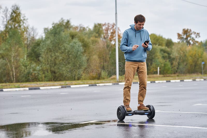 Man Riding on the Hoverboard and Using Smartphone Outdoor Editorial ...
