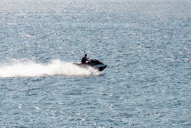 Man Riding a Jet Ski Shooting in Backlit Stock Image - Image of action ...