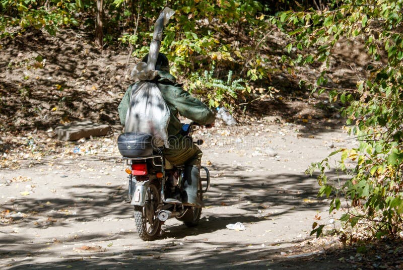 A Man is Riding a Motorcycle with a Bag on the Back Stock Image - Image ...