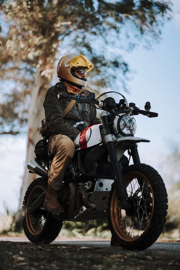 Man Riding Motorcycle Down Road Next To Tree and Bushy Stock Image ...