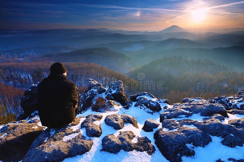 Man on Rocks and Looking at the Snow-covered Hills. Dark Sky Stock ...