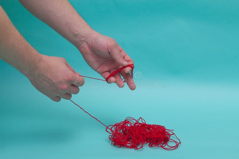 A Man Rolls the Thread into a Tangle. the Man Begins To Reel the Red ...