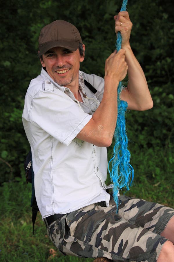 Man on rope swing stock photo. Image of swinging, happy - 17826914