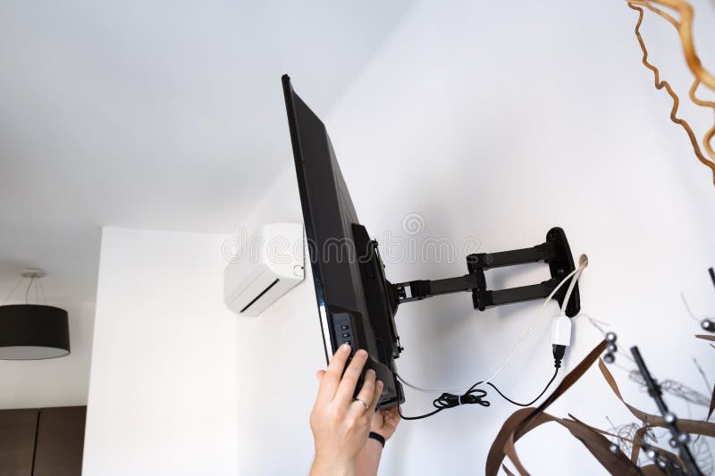 Flat Screen TV Hanging on a Metal Mount on the White Wall in the Room ...