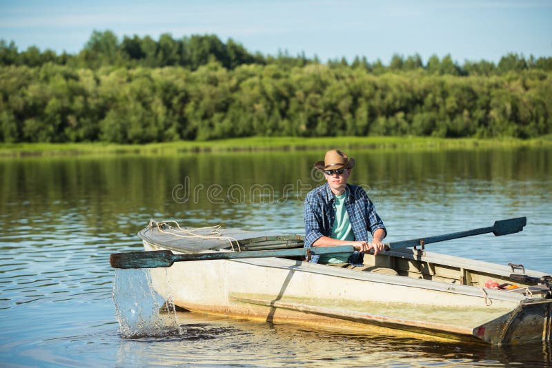 Man in a rowing boat. stock image. Image of sunglasses - 93754143