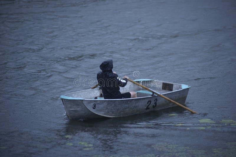 Man Rowing Boat in Rain Falling, Evening Stock Image - Image of oars ...
