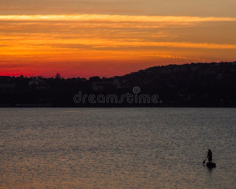 Man Rowing Boat at Sunset stock image. Image of skies - 109041429