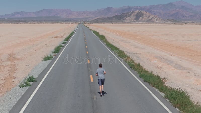 Man Running Down the Endless Road in the Desert. Aerial View of the ...