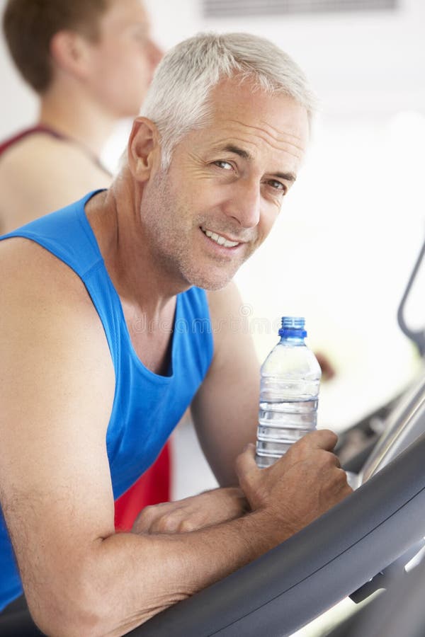 Man on Running Machine in Gym Drinking Water Stock Image - Image of ...