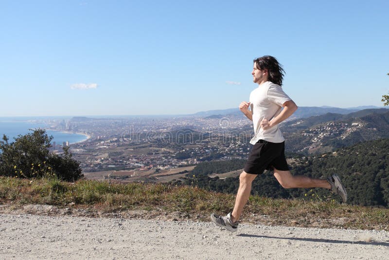Man Running in the Mountain with a Big City in the Background Stock ...