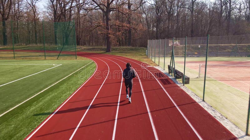 Man Running at Race Track at Stadium Stock Footage - Video of distance ...