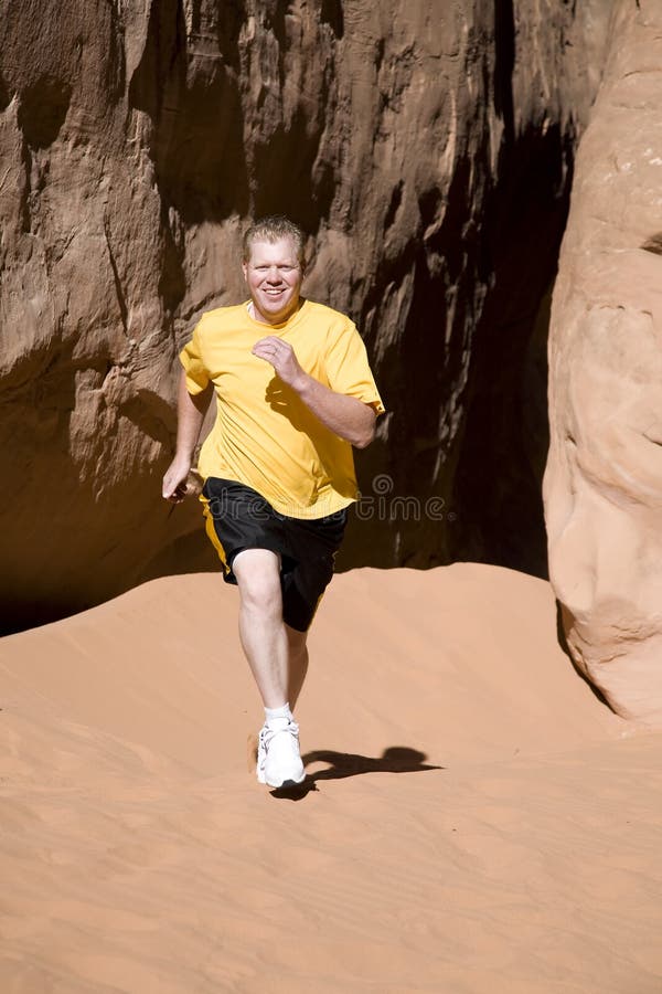 Man Running in Sand with Yellow Shirt Stock Image - Image of rock, sand ...